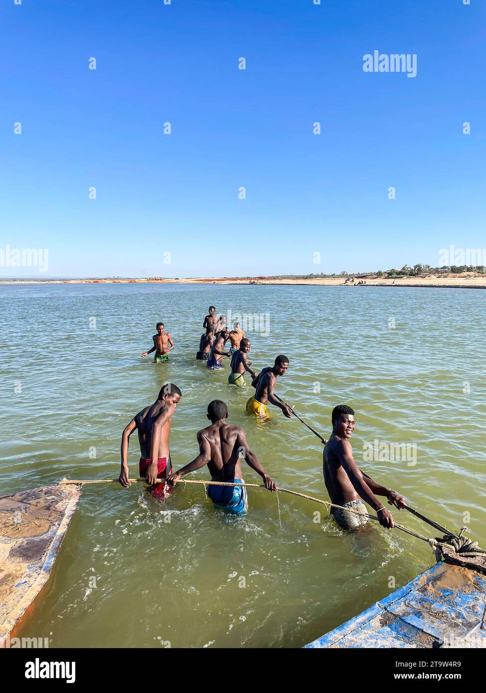 Madagascar, Tsiribihina river, young men tow barge on river Stock Photo ...