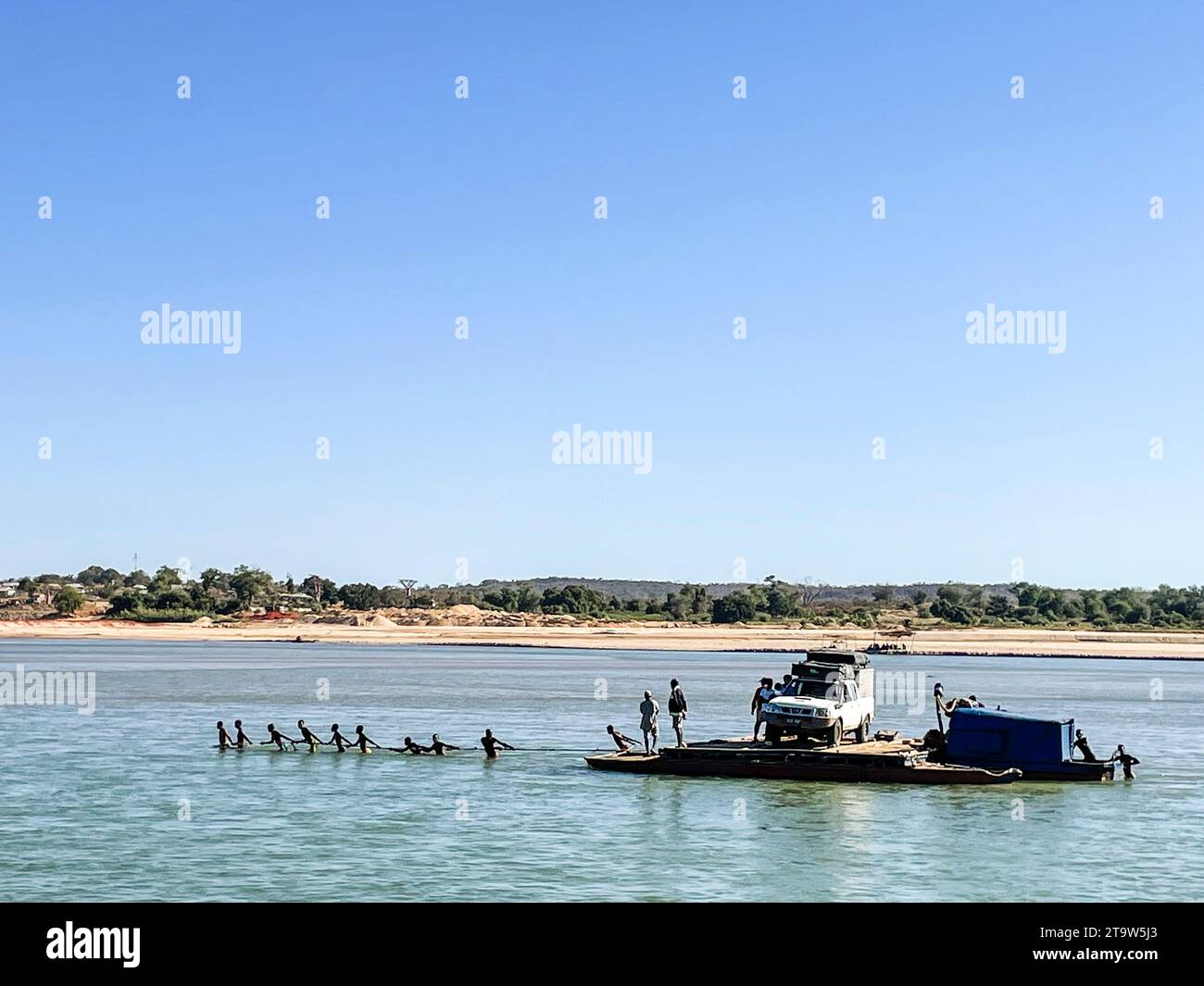 Madagascar, Tsiribihina river, young men tow barge on river Stock Photo ...