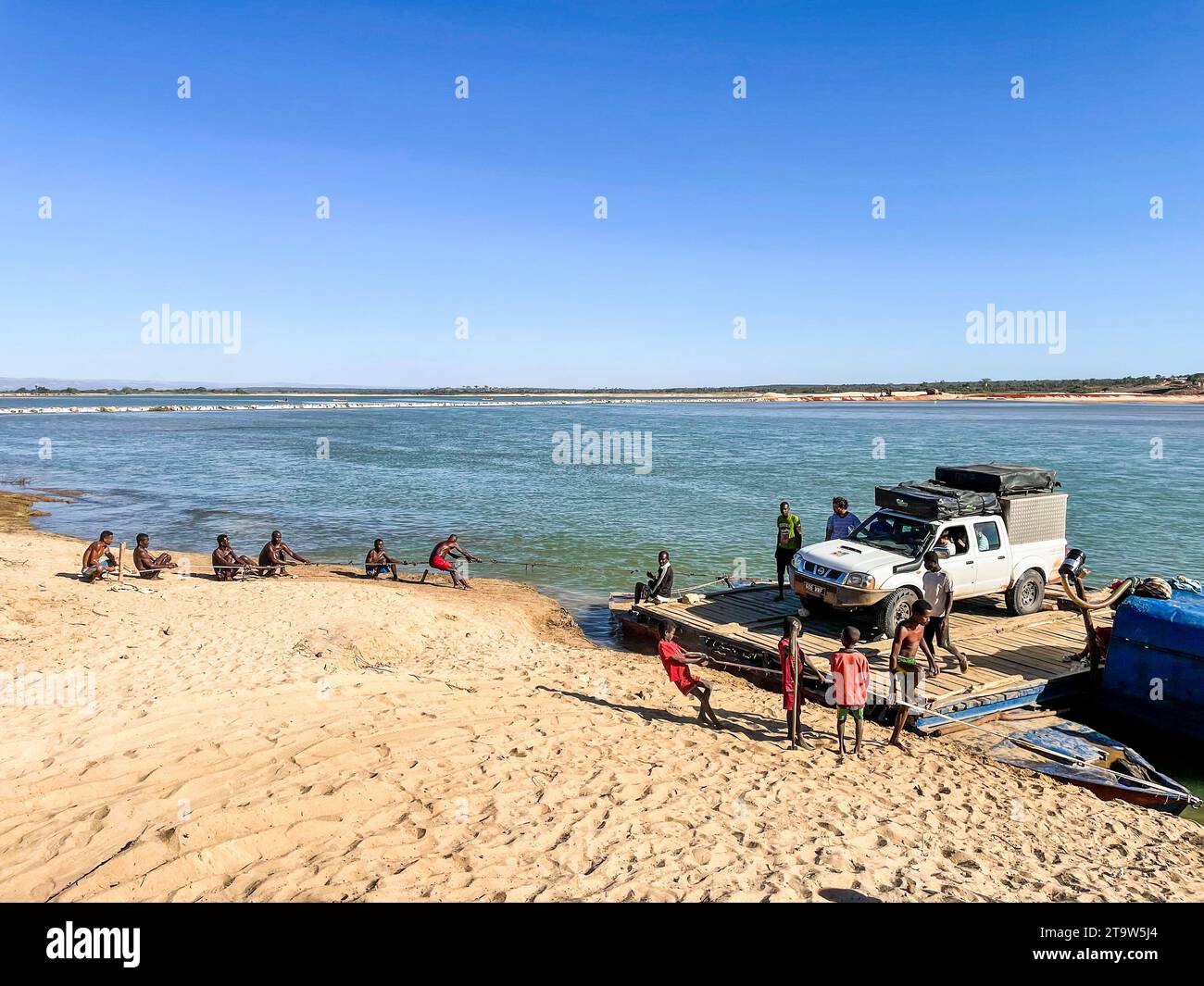 Madagascar, Tsiribihina river, young men tow barge on river Stock Photo ...