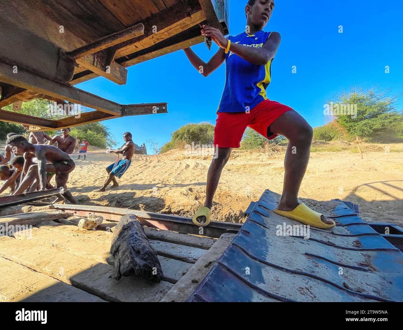 Madagascar, Tsiribihina river, young men tow barge on river Stock Photo ...