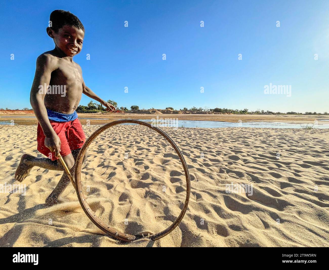 Madagascar, child plays on the sandy banks of the Tsiribihina river ...
