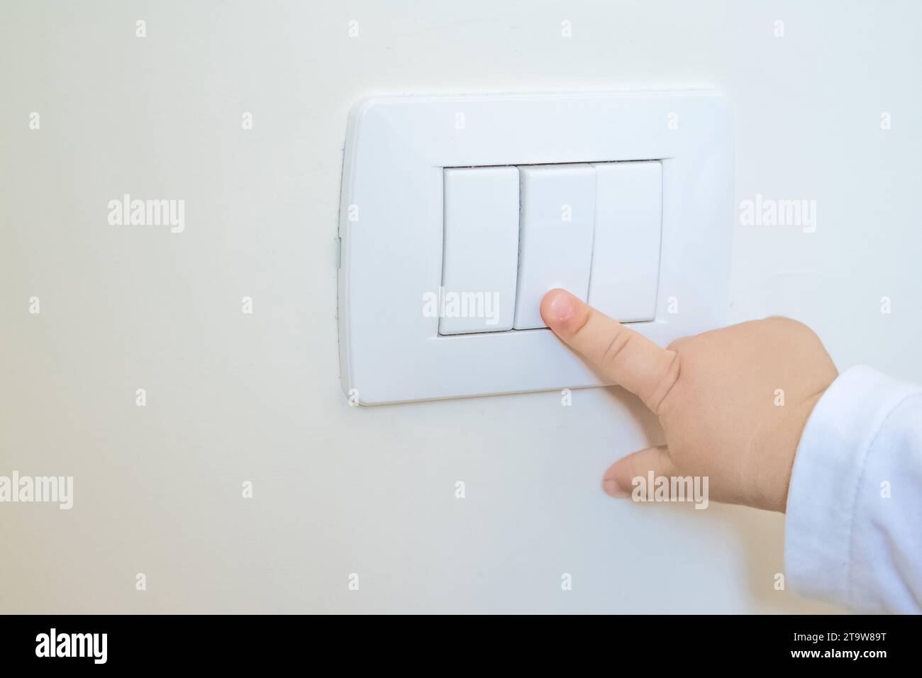 adorable little boy child turning on the white light-switch with his ...