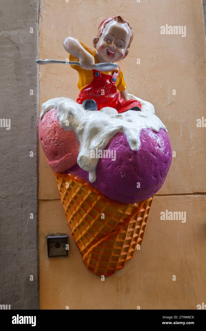 Sign in the shape of an ice cream cone topped with a child eating ice ...