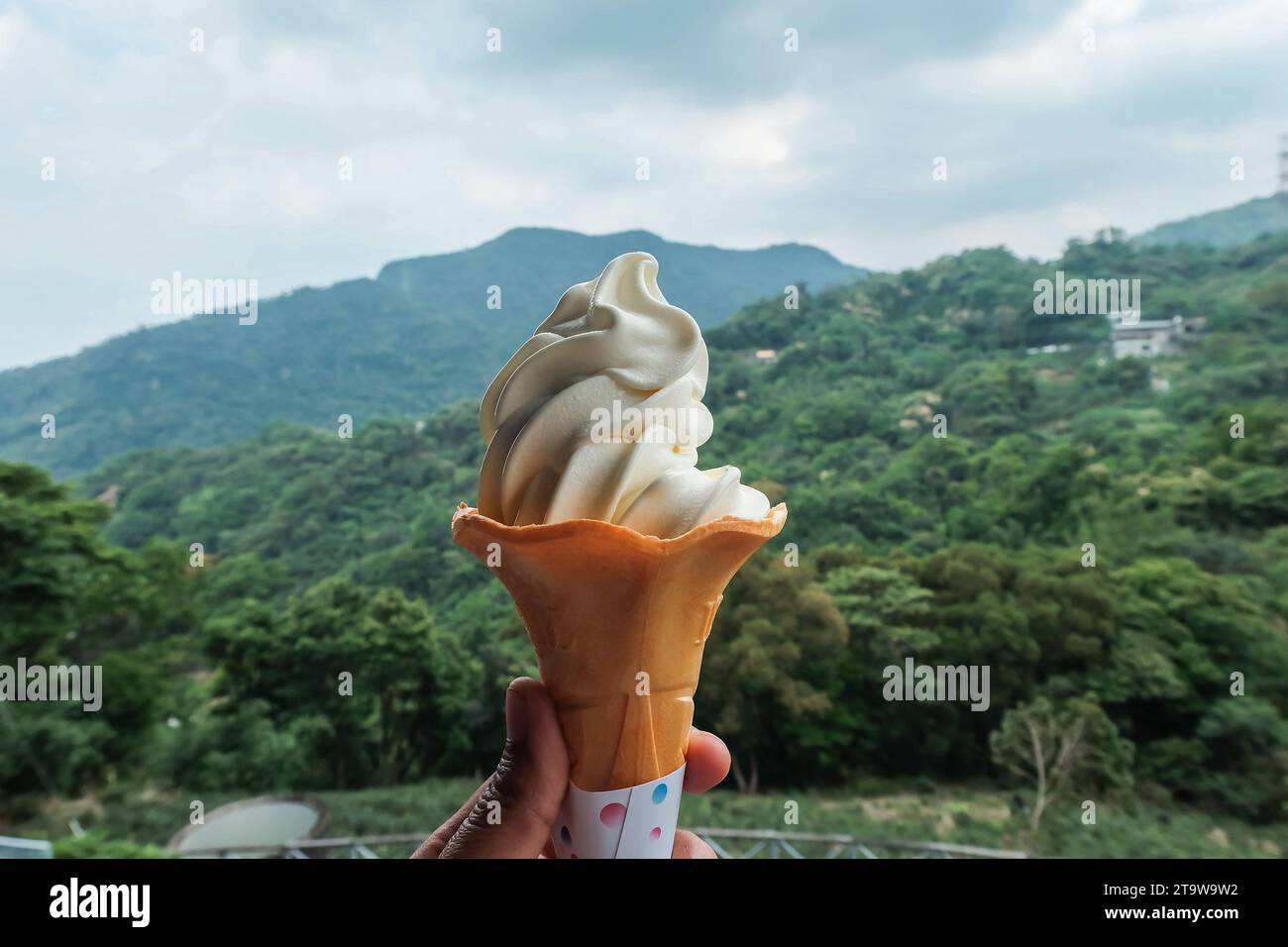 Close up a hand holding cone of ice cream with blur background of a ...