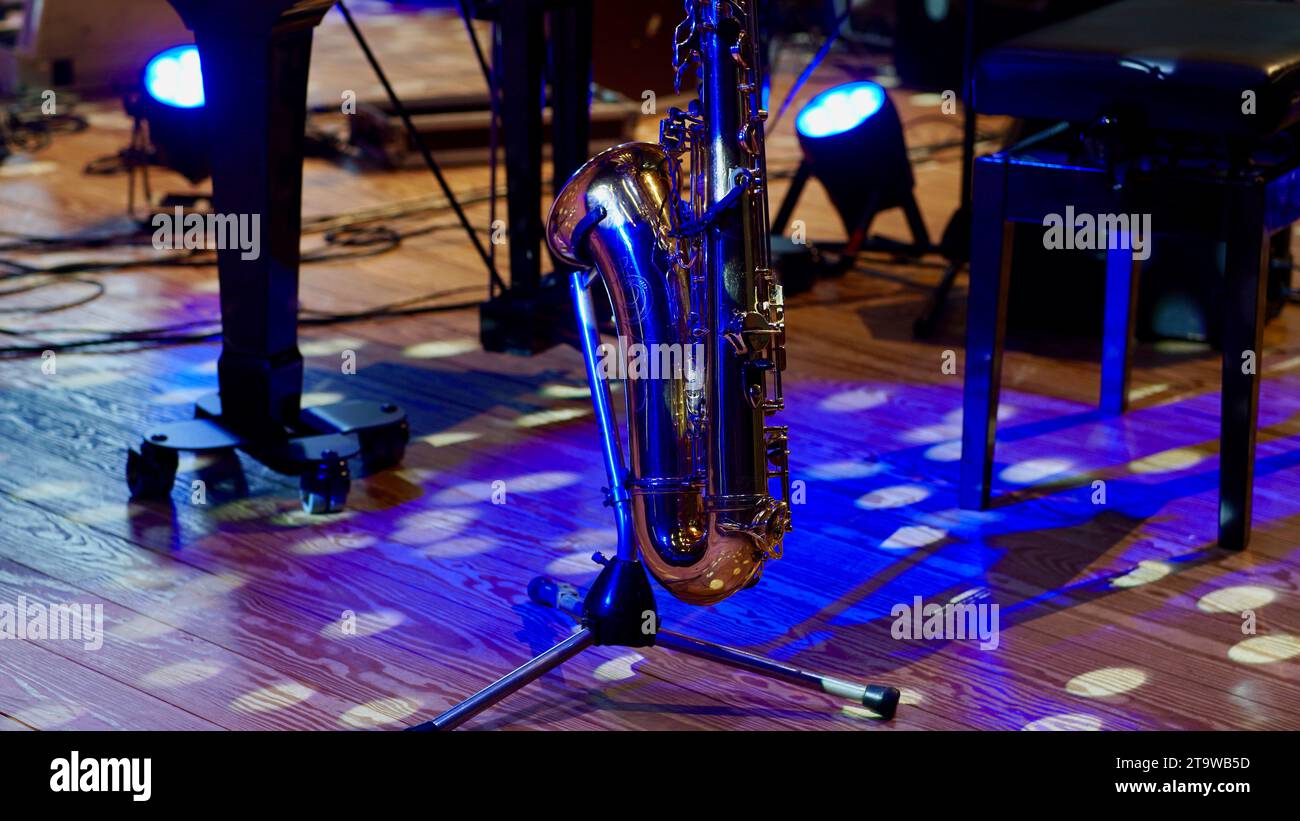 Saxophone on stage in blue light Stock Photo - Alamy