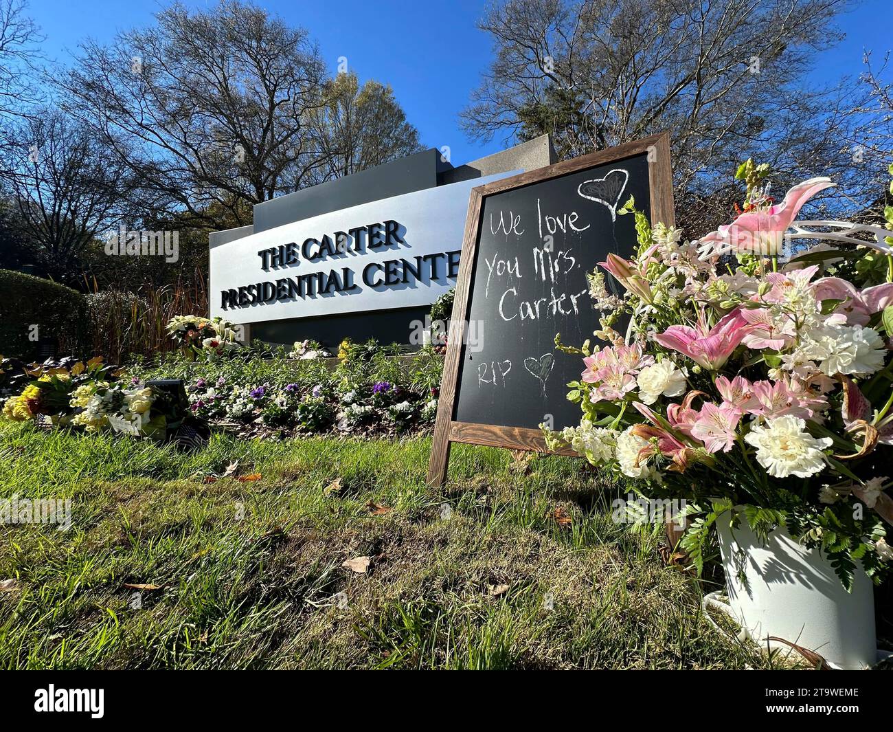 Bouquets of flowers and a sign in tribute to Rosalynn Carter are seen ...