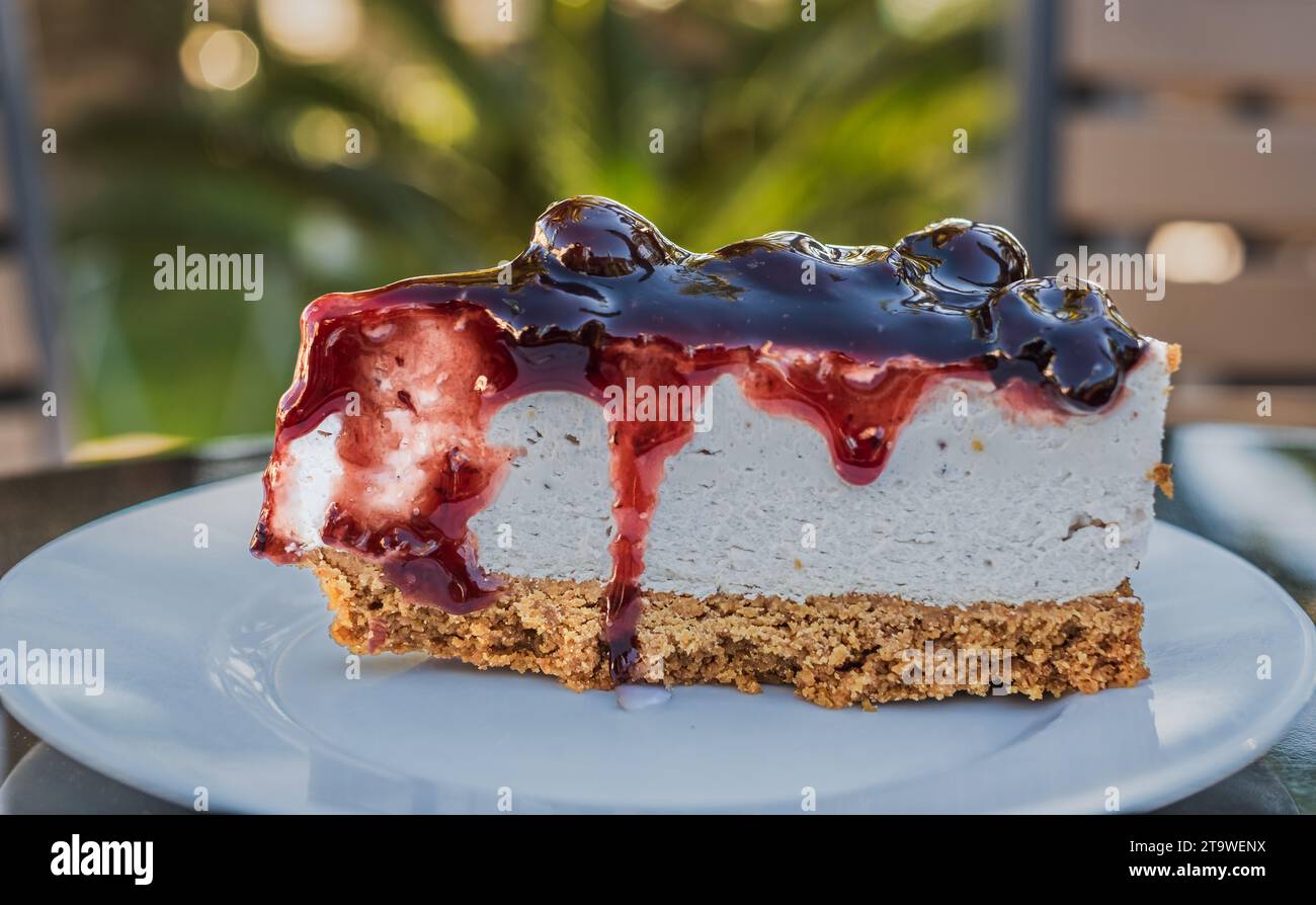 Slice of Cheesecake. Tasty cheesecake with cherry topping on a white ...
