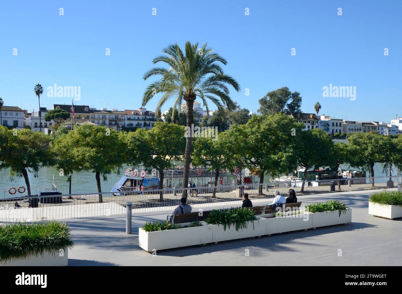 Seville, Spain - November 25, 2023: People at bench in walkway along ...