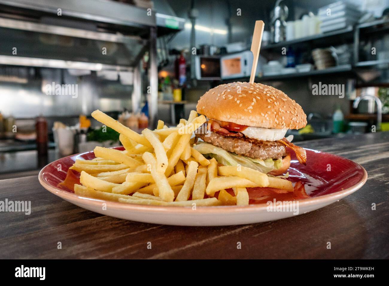 a freshly grilled complete beef burger with bacon and egg served with ...