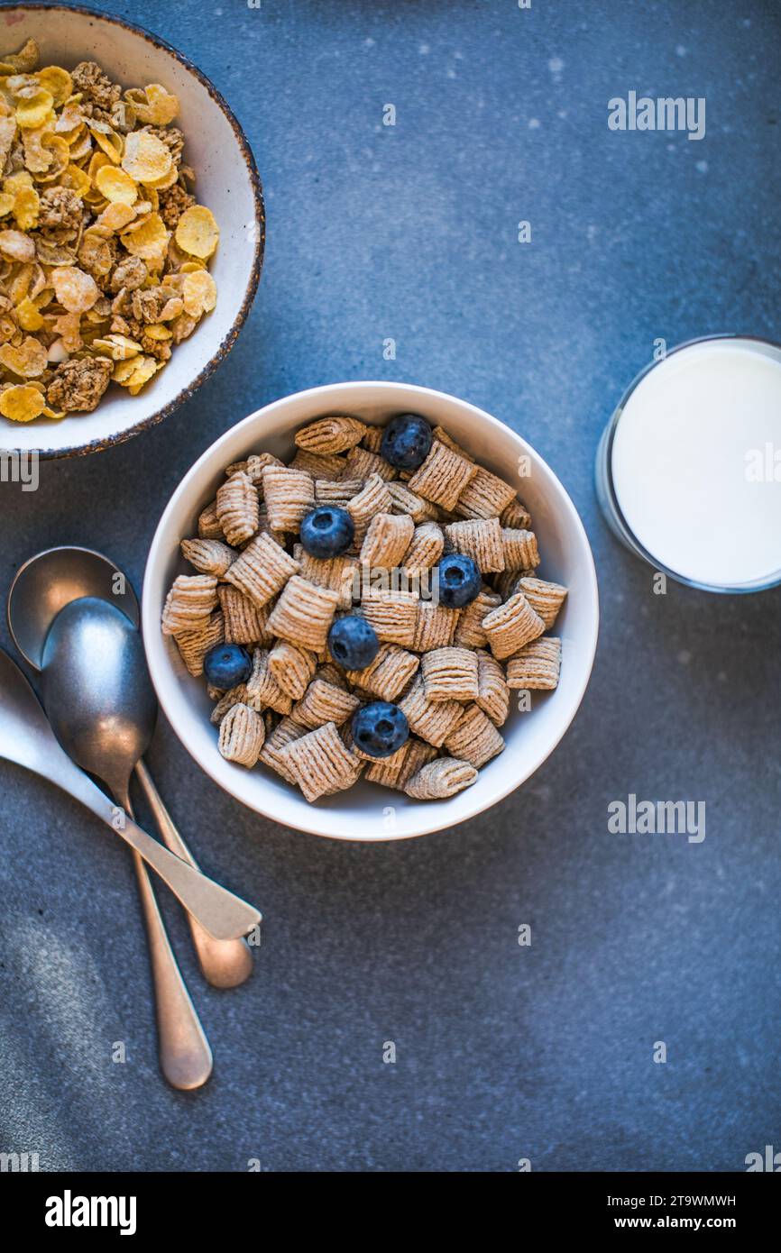 Variety of breakfast whole grain cereals and muesli in bowls on a light ...