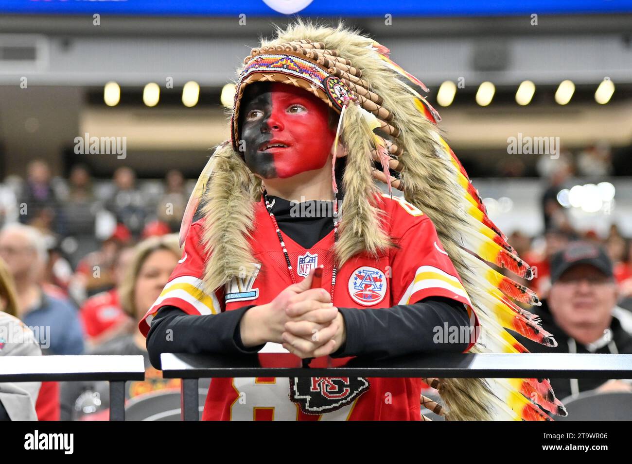 A young Kansas City Chiefs fan, dressed with a headdress and face paint ...