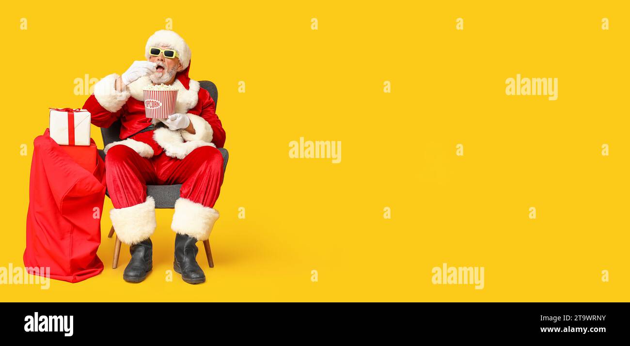 Santa Claus with popcorn watching Christmas movie against yellow ...