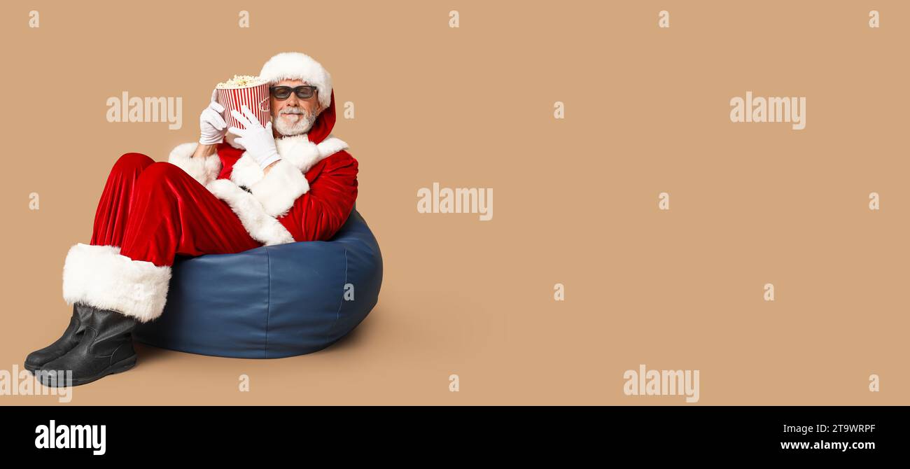 Santa Claus with popcorn watching Christmas movie against beige ...