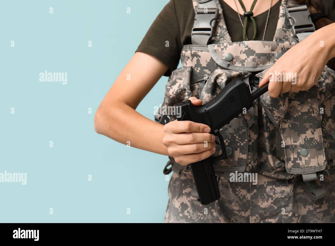 Female soldier reloading handgun on blue background, closeup Stock ...