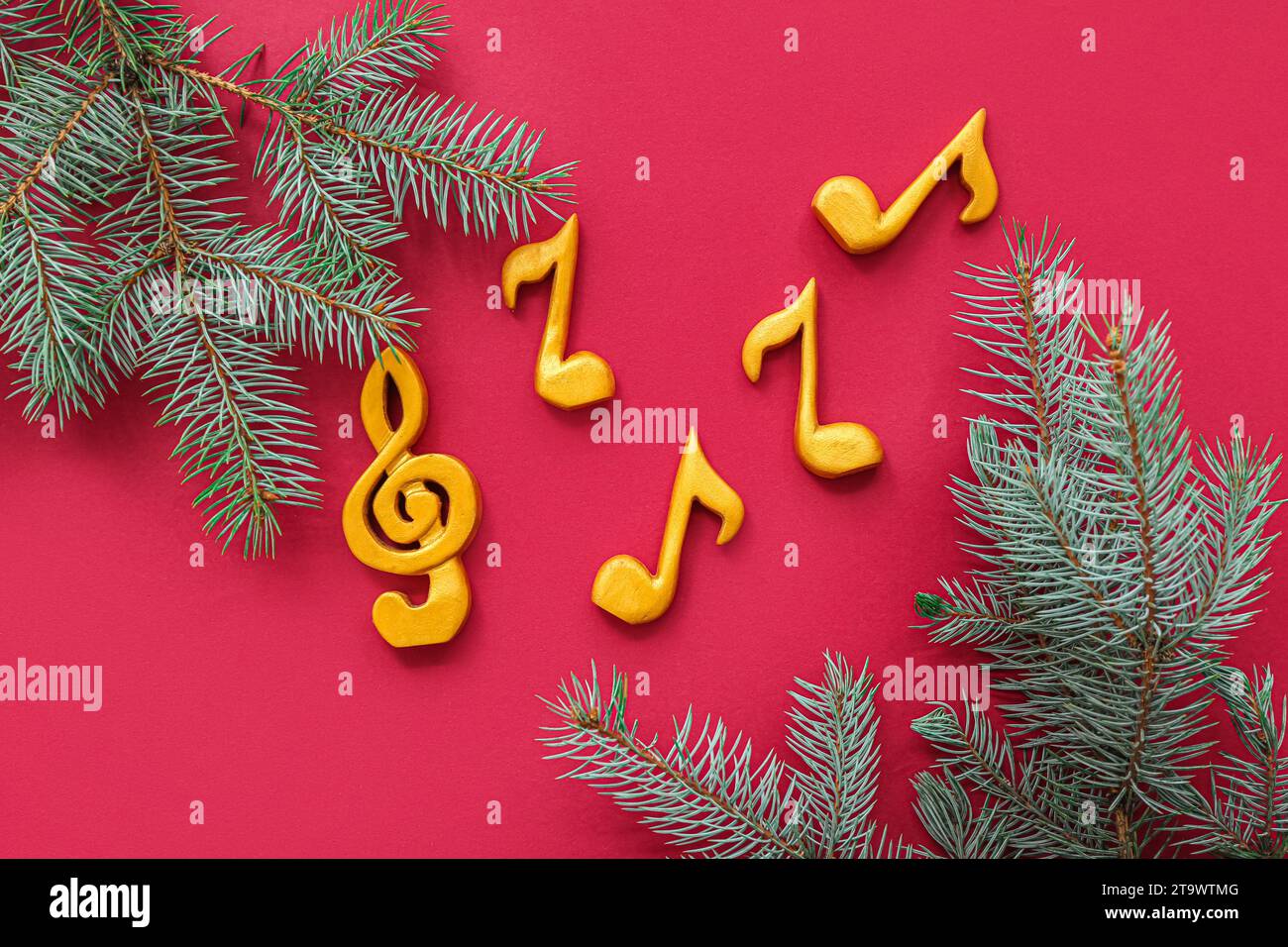 Music notes with fir twigs on red background Stock Photo - Alamy