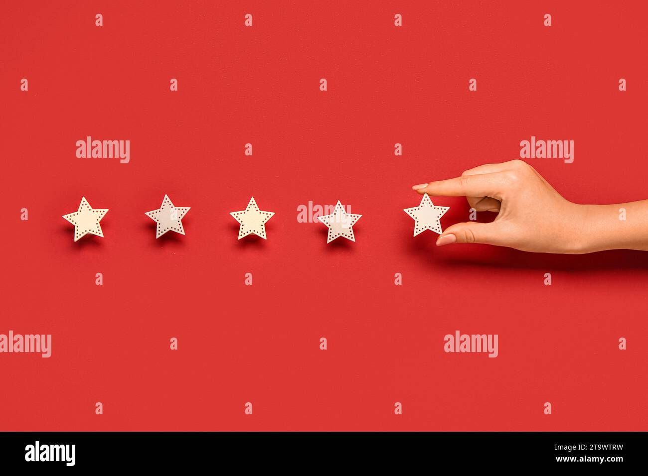 Female hand with five stars rating on red background. Customer ...