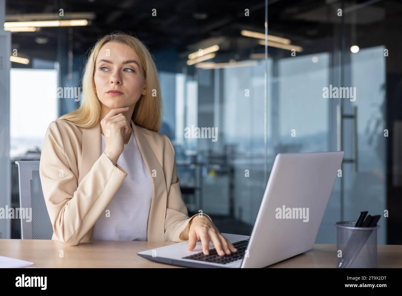 Serious concentrated thinking woman at workplace inside office working ...