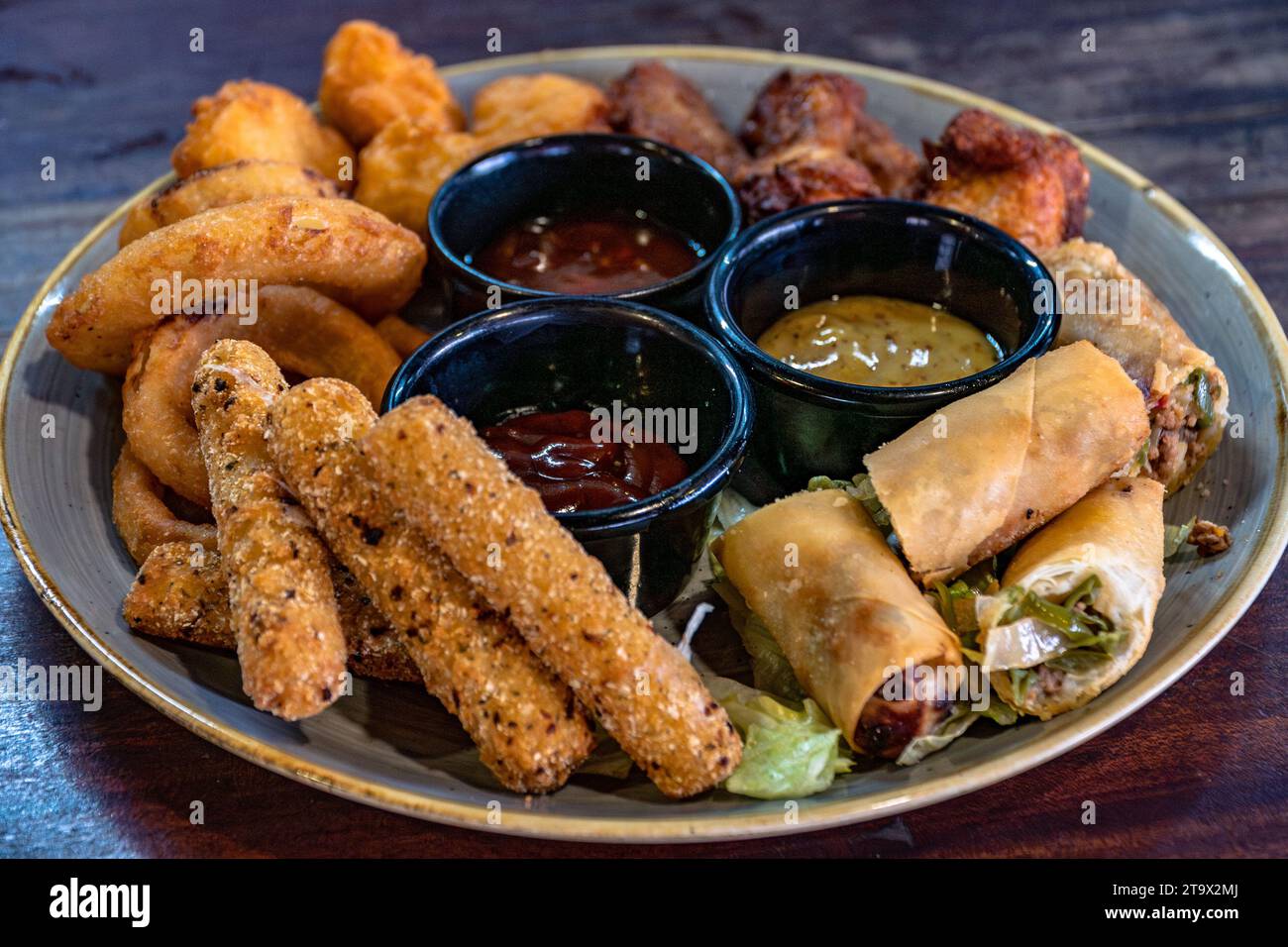 a close up image of a mixed appetizer combo platter served with dipping ...