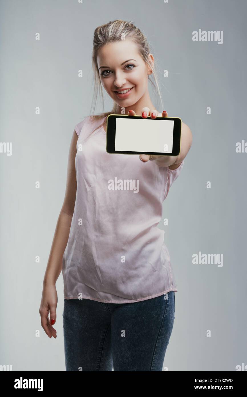 Engaging model demonstrates a phone, symbolizing access to digital ...