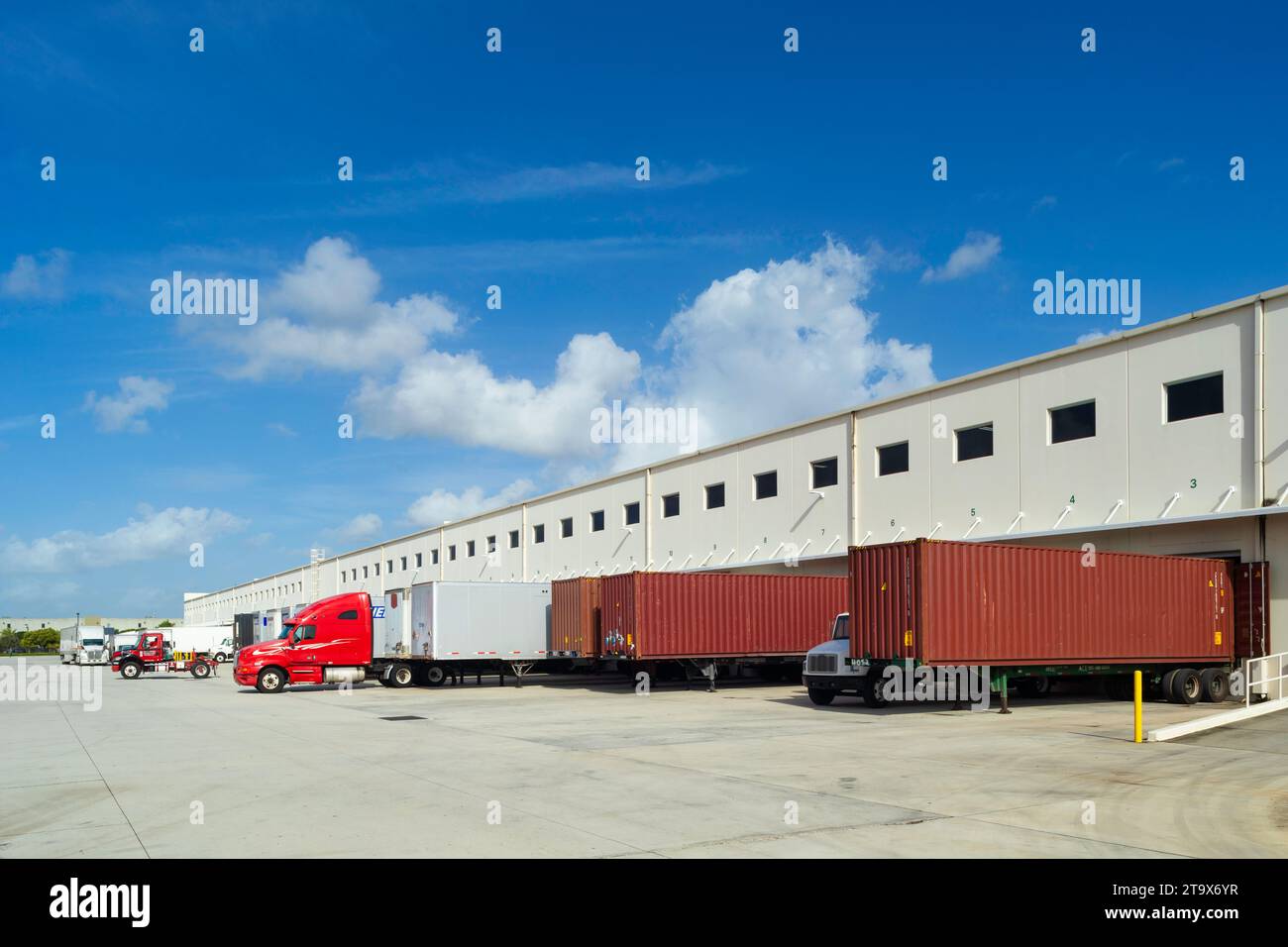 Distribution warehouse with delivery trucks parked on loading docks ...