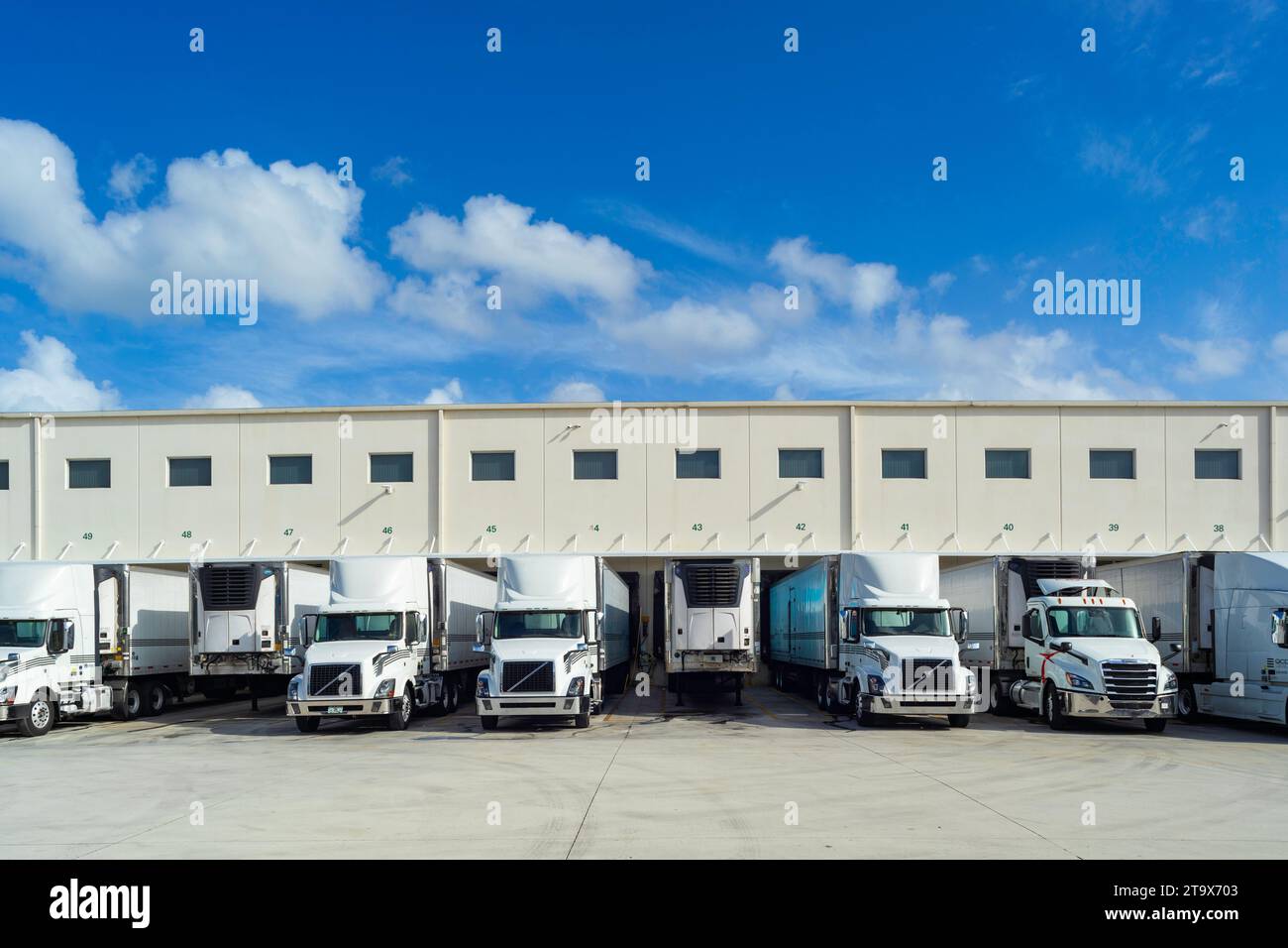 Distribution warehouse with delivery trucks parked on loading docks ...