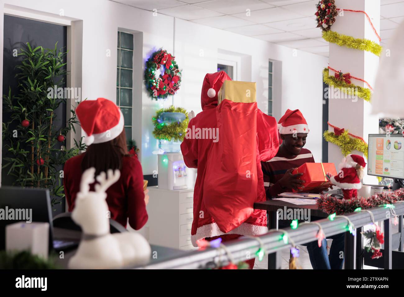 Happy workers surprised by Santa with gifts during Christmas holiday ...