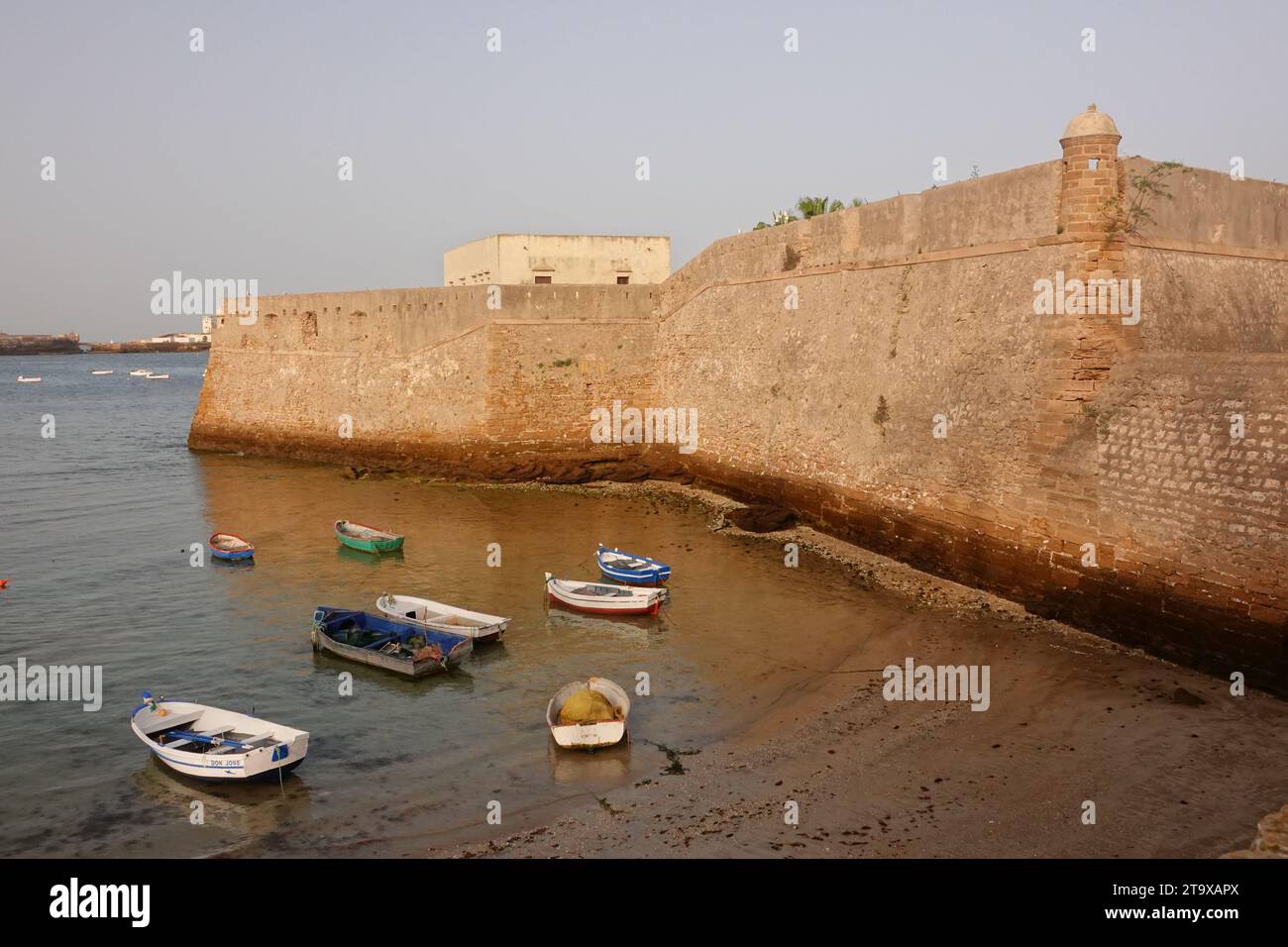 Fishing boats moored by the walls of the Castillo de Santa Catalina ...