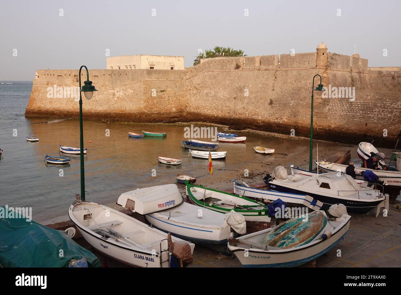 Fishing boats moored by the walls of the Castillo de Santa Catalina ...