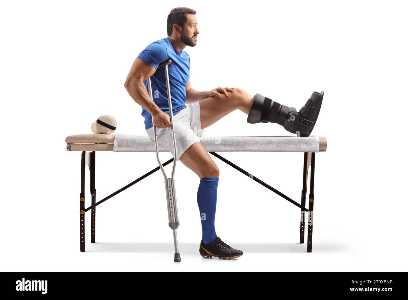Male athlete with crutches and injured foot sitting on a physical ...