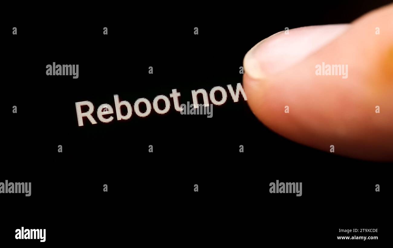 Man hand finger pressing the reboot now computer restart button on a ...