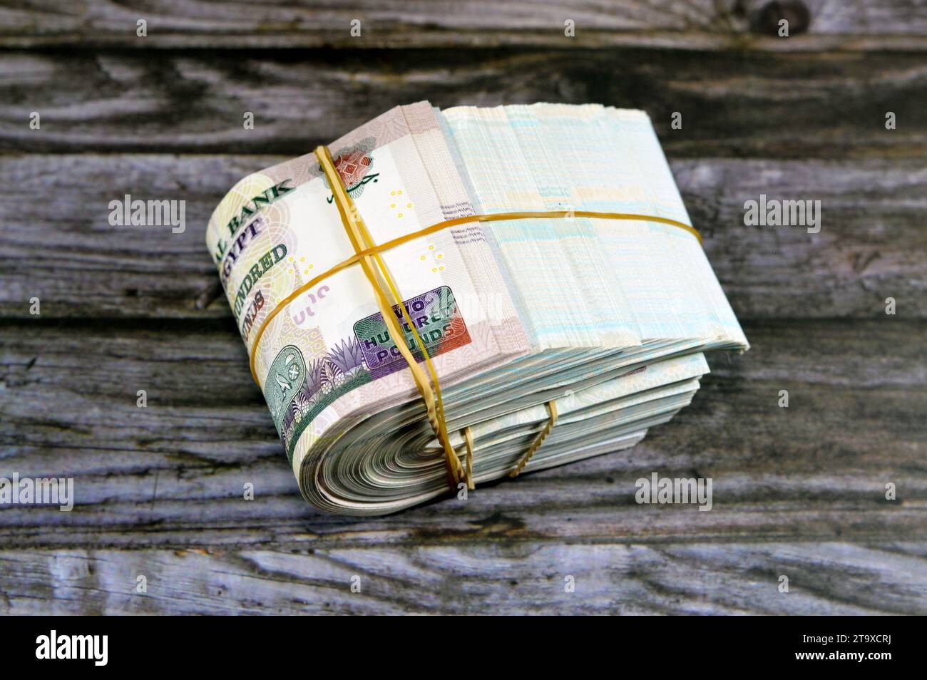 Folded Egyptian money isolated on wooden background, 200 LE 100 EGP LE ... Folded Egyptian money isolated on wooden background, 200 LE 100 EGP LE ...