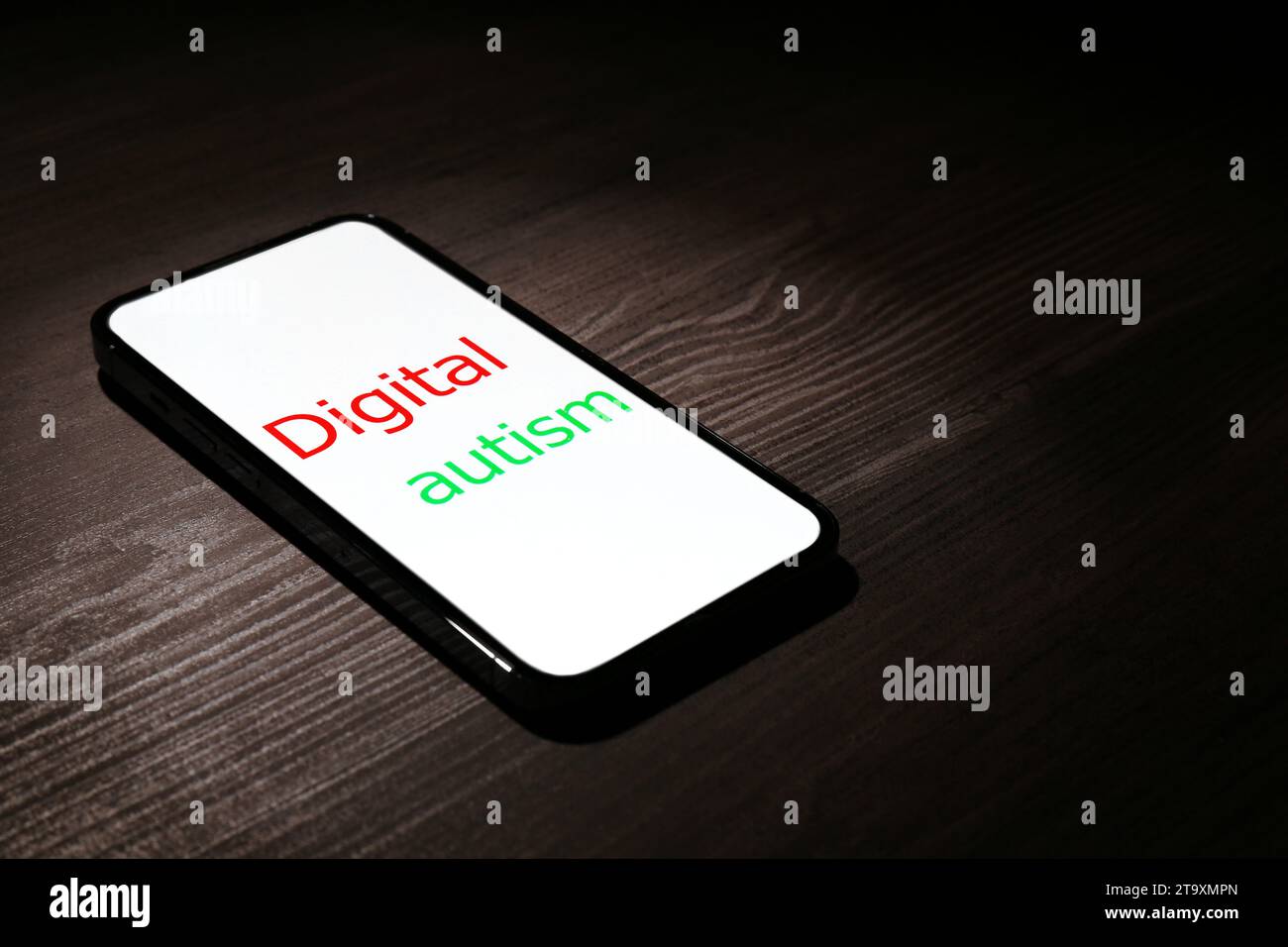 Smartphone with phrase Digital Autism on wooden table, space for text ...