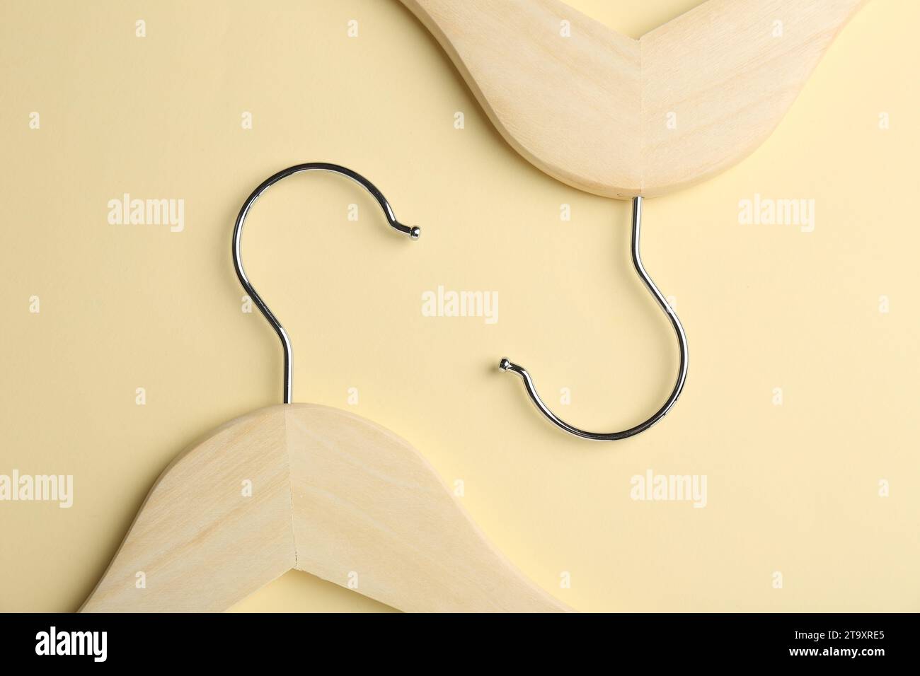 Wooden hangers on pale yellow background, flat lay Stock Photo - Alamy