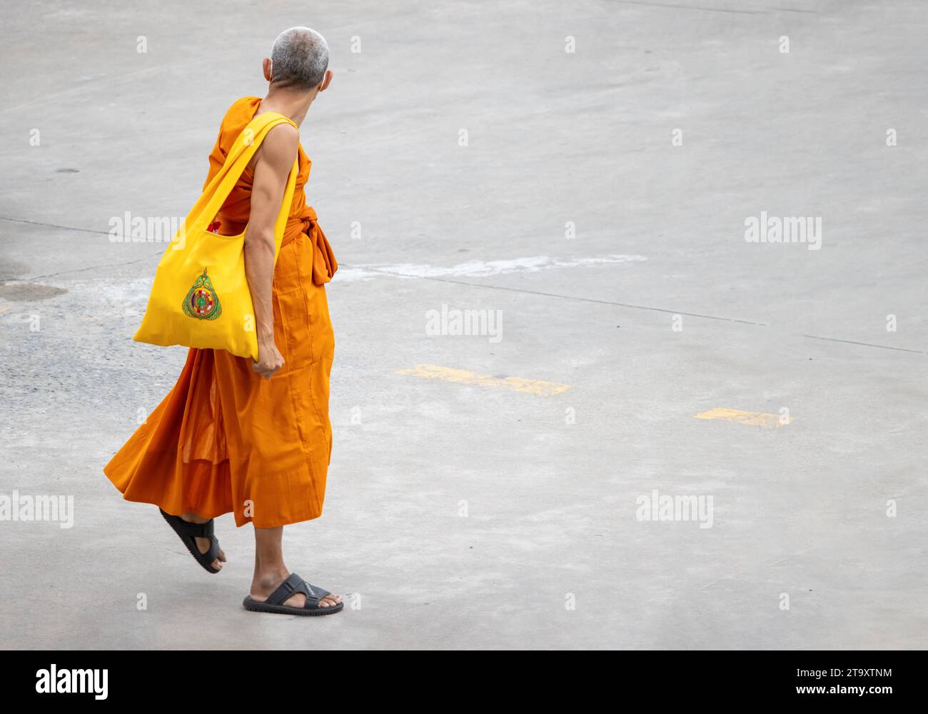 A Buddhist monk with a bag walks on the street, Thailand Stock Photo ...