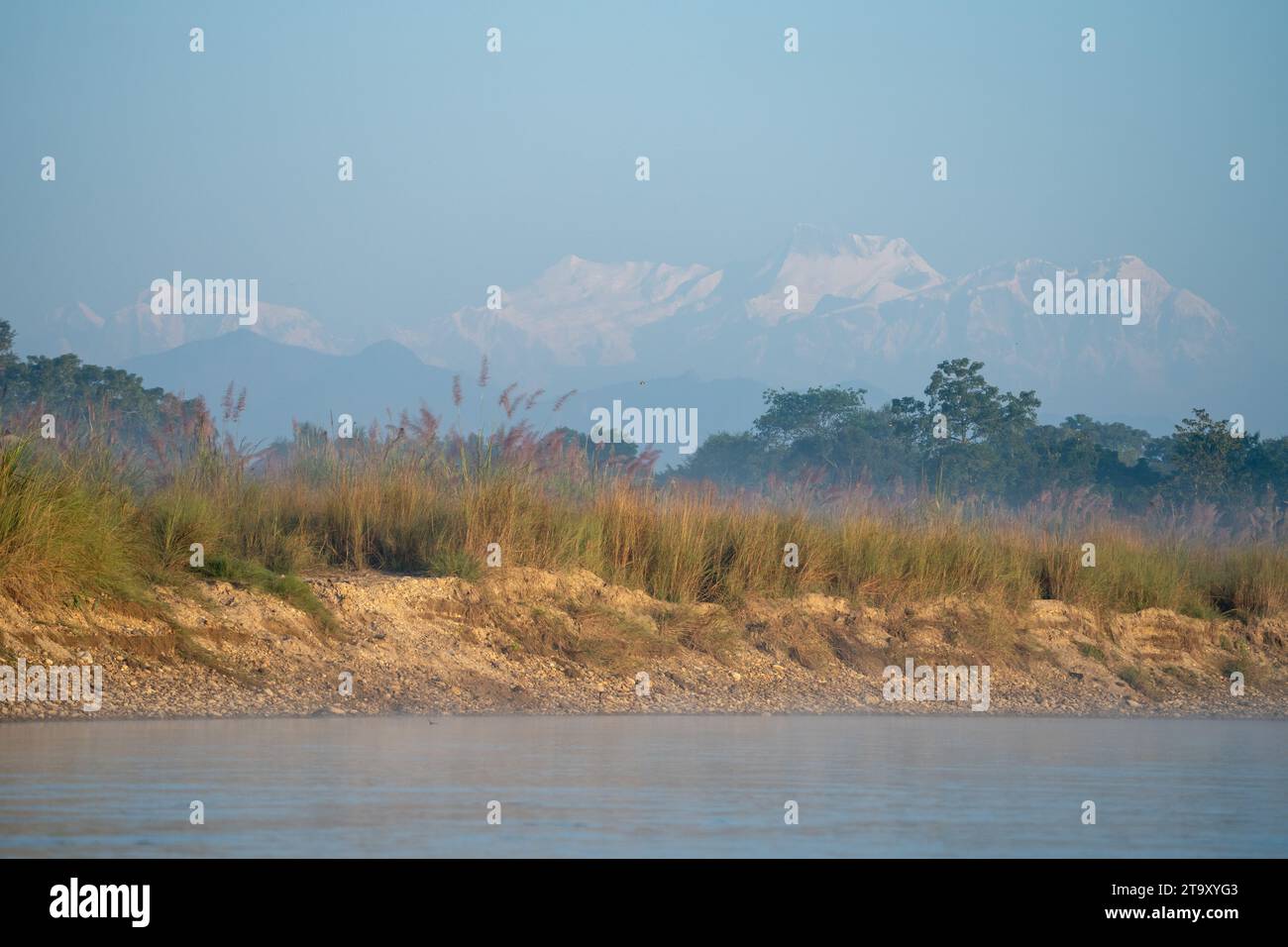 A view of the Himalaya Mountains from a river in the flatlands of Nepal ...