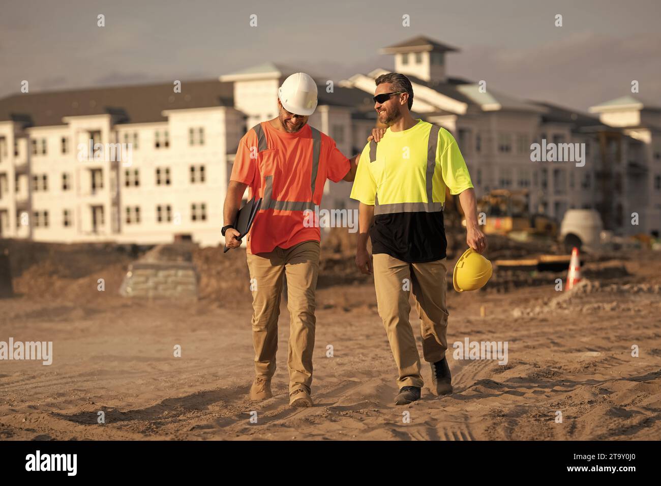 Construction workers working at construction site. Men wearing safety ...