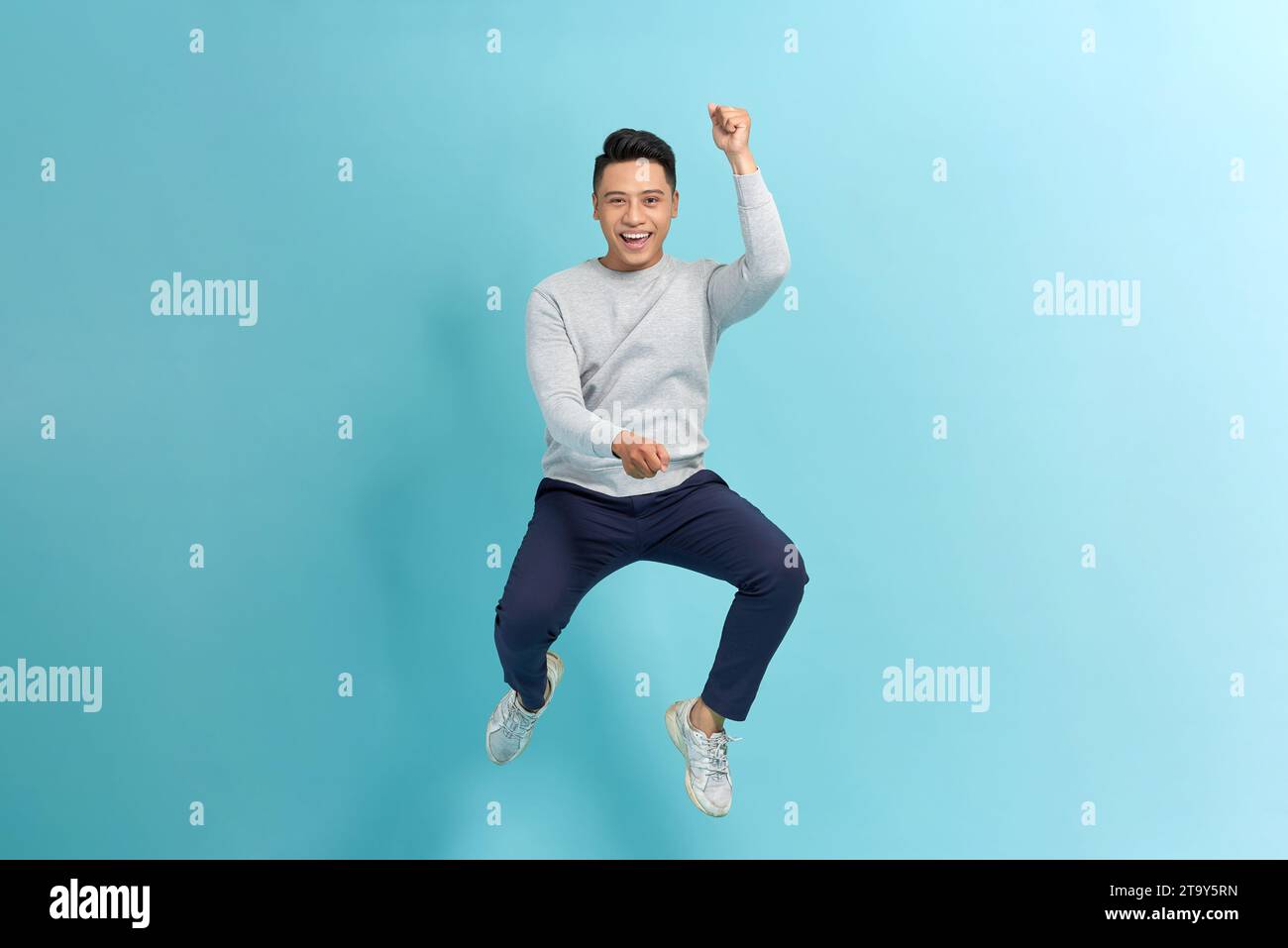 Portrait of young male cheerful confident and excited jump in air and ...