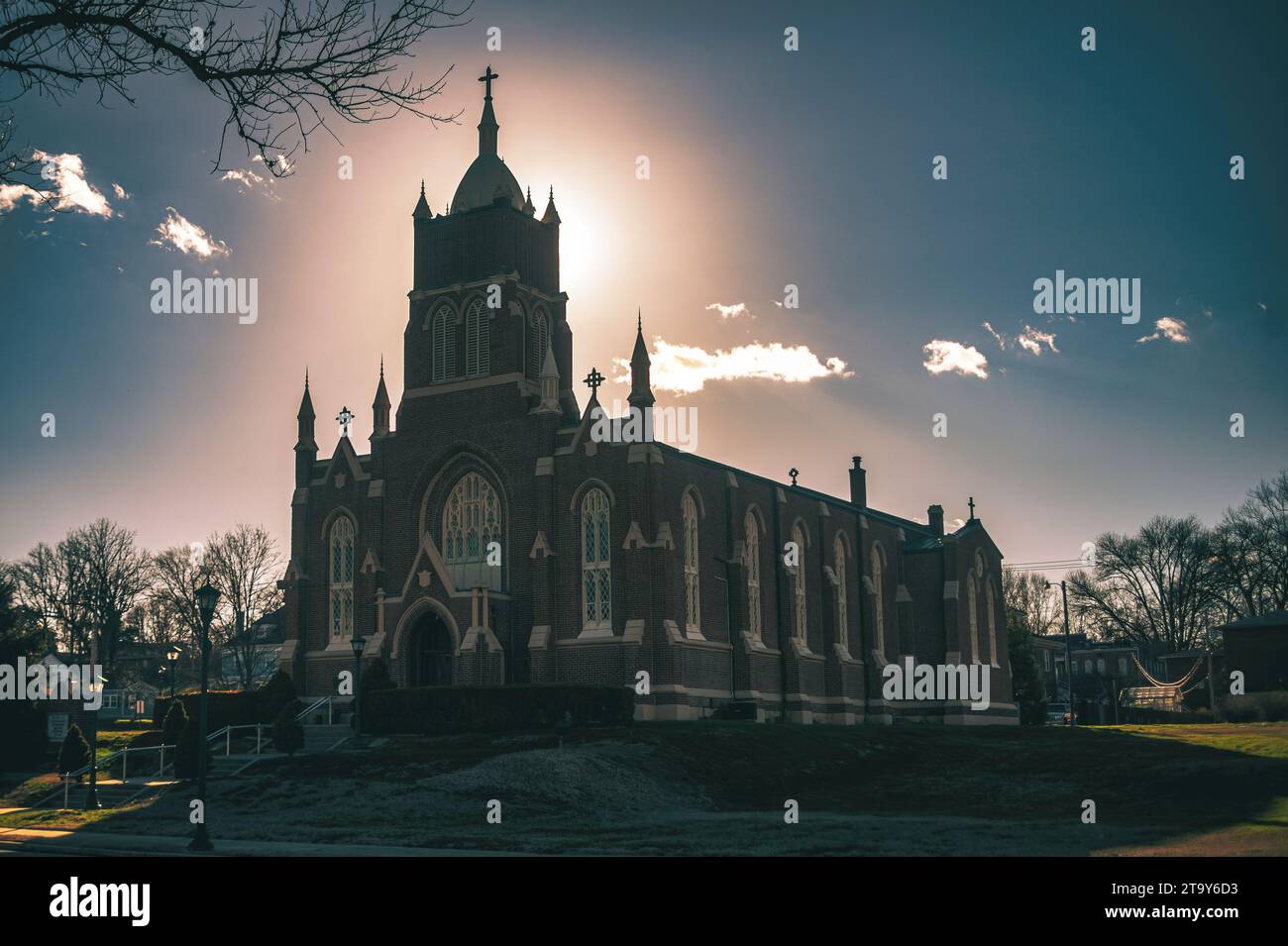 A grand, awe-inspiring church is illuminated by the setting sun, with ...