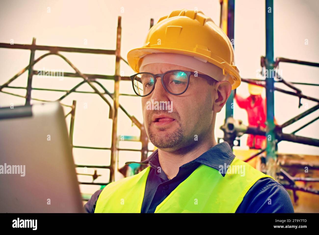 A portrait of an industrial man engineer wearing glasses with laptop in ...