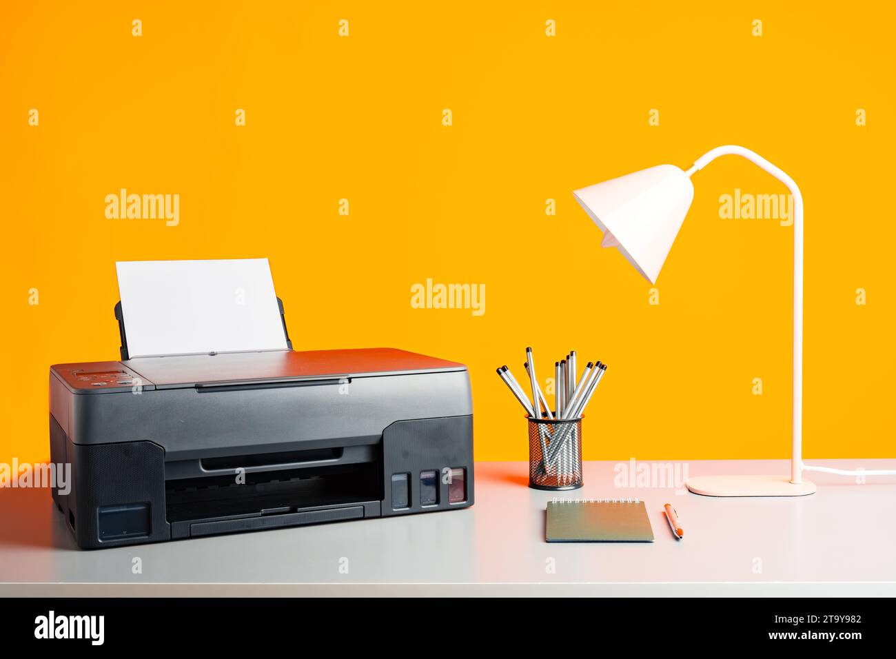 Laser printer on desk against yellow background Stock Photo - Alamy