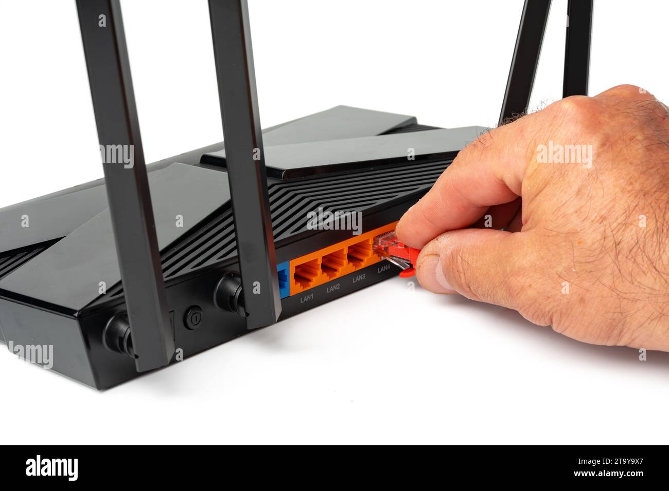 Man's hand plugging internet cable into wifi router Stock Photo - Alamy