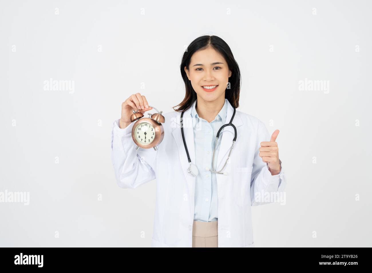 Portrait of a female doctor smiling and holding clock. isolated in ...