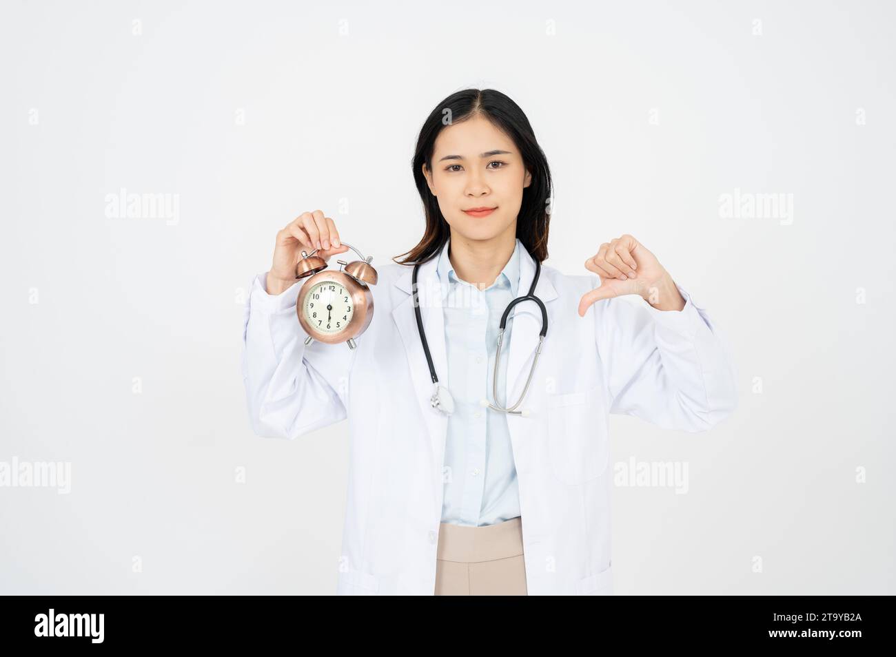 Portrait of a female doctor smiling and holding clock. isolated in ...
