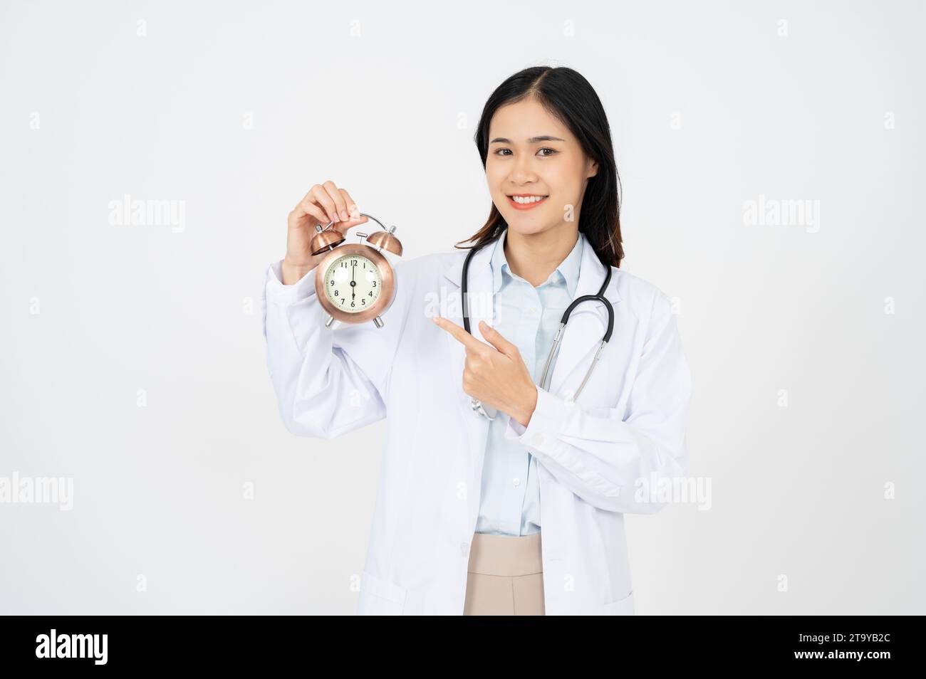 Portrait of a female doctor smiling and holding clock. isolated in ...