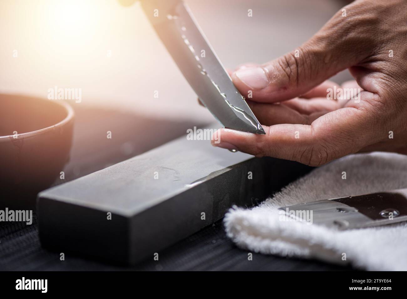 Knife sharpening with whetstone or grindstone Stock Photo - Alamy