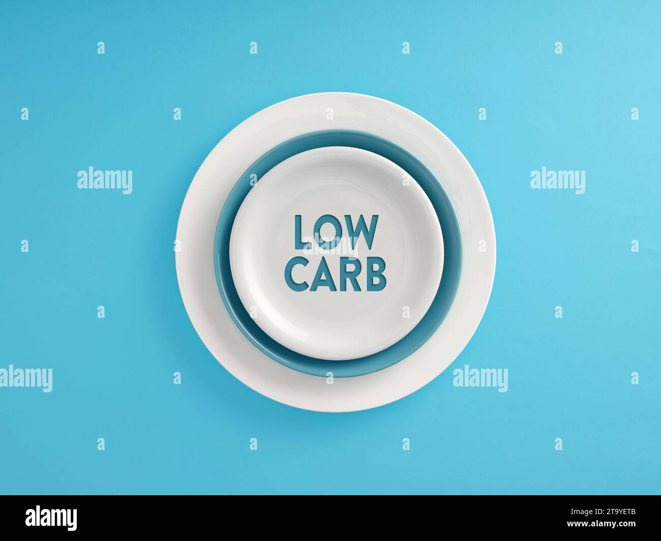 The word Low Carb written on a plate over blue background. Eating fewer ...