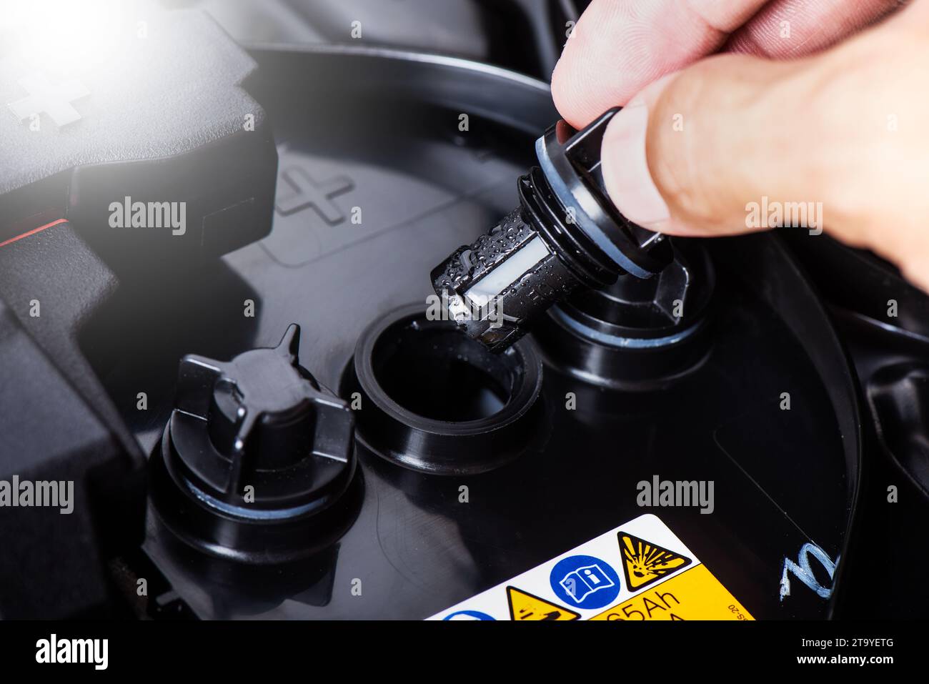 Checking a car battery in the engine room. Car maintenance concept ...