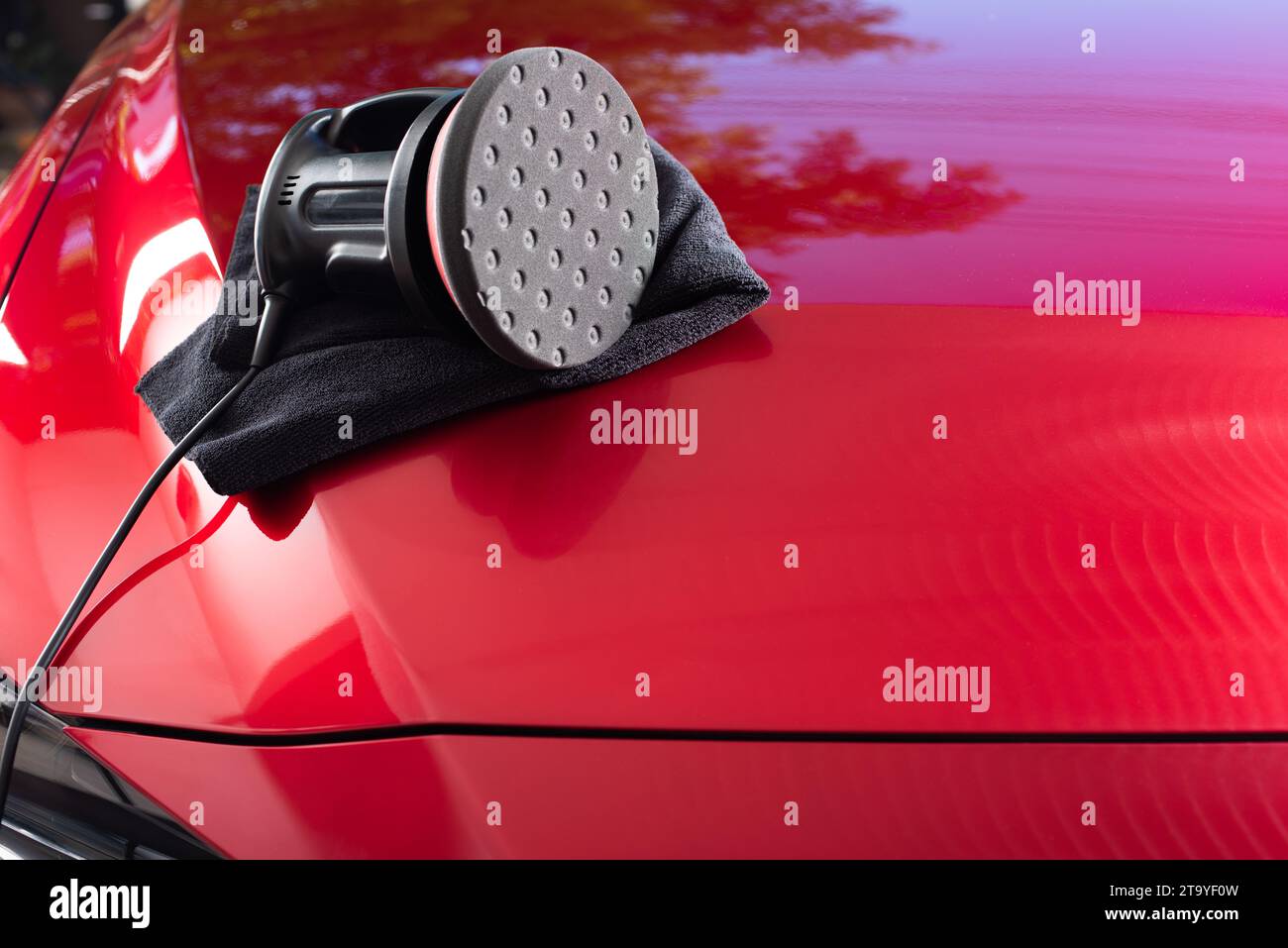 DA polisher with foam pad and microfiber cloth on the bonnet of the red ...