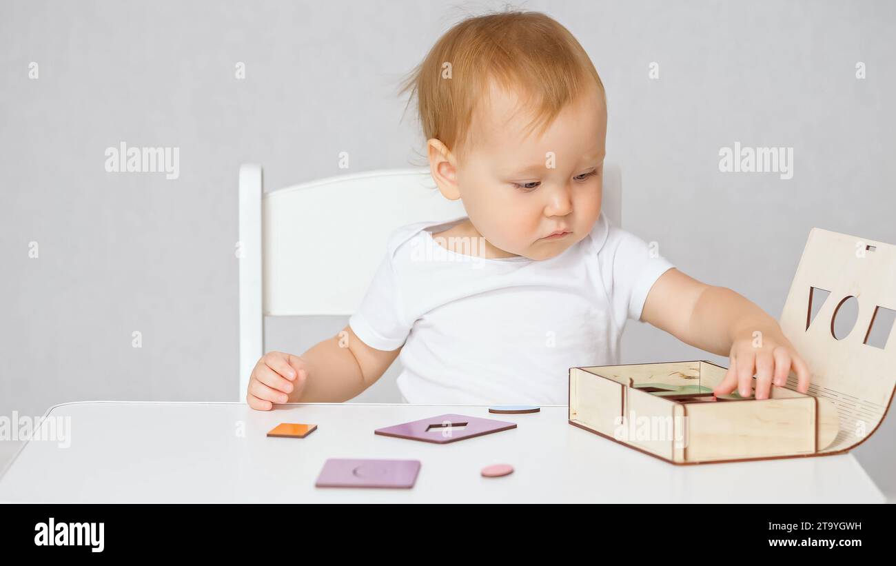 Toddler with blonde hair lays out cut out cards from box Stock Photo ...