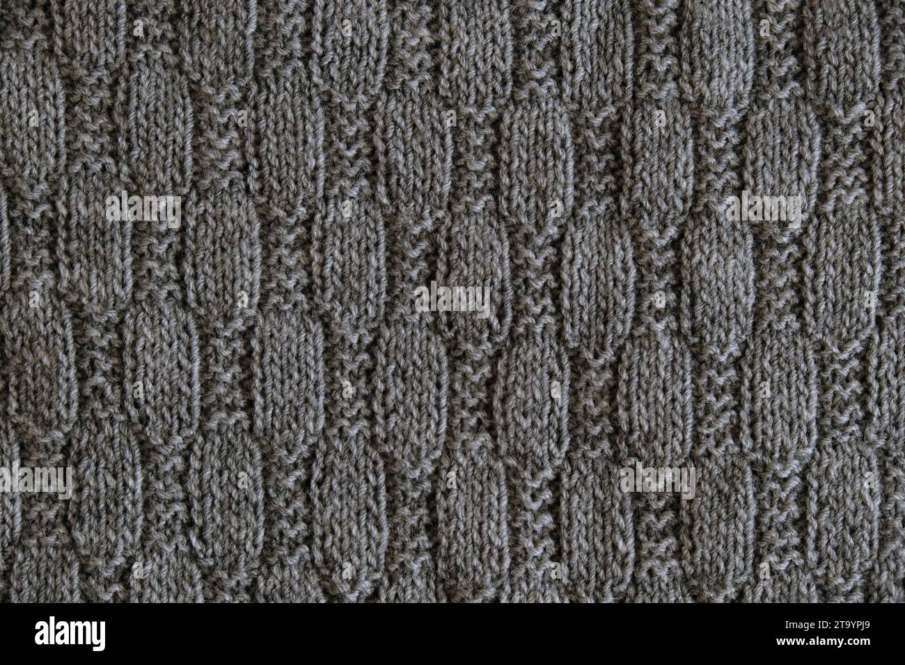 Background with gray knitted leaf shape, knitting pattern with cables ...